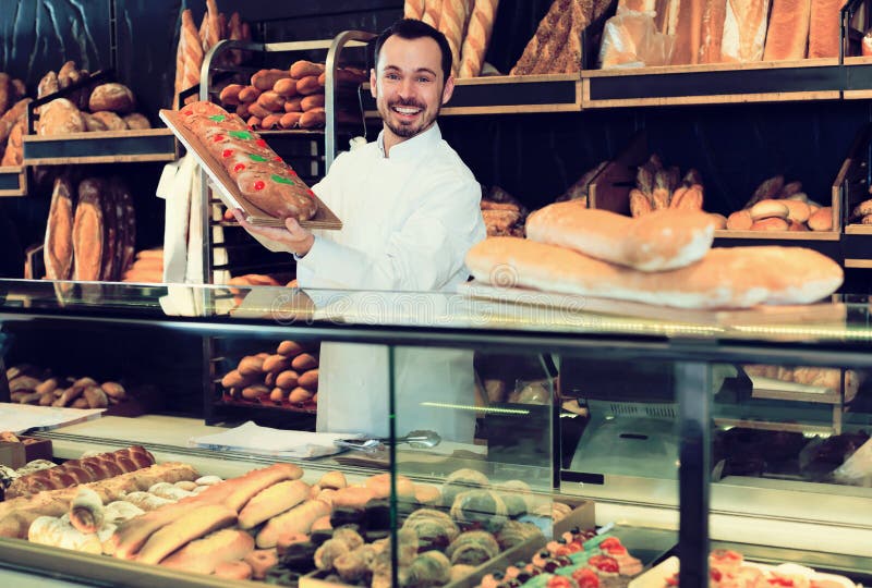 Smiling Assistant Demonstrating Festive Cake in Bakery Stock Photo ...