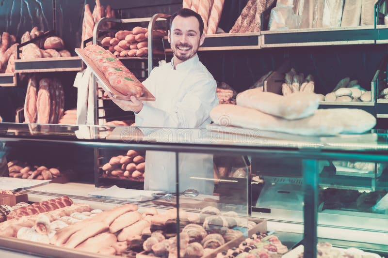 Smiling Assistant Demonstrating Festive Cake in Bakery Stock Image ...