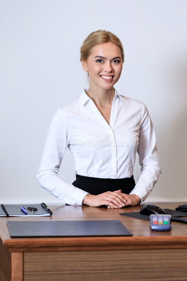 Smiling Attractive Receptionist Standing at Reception Desk Stock Photo ...