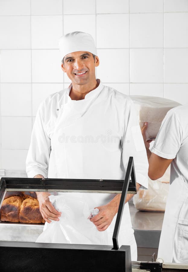 Smiling Baker Packing Breads in Bakery Stock Image - Image of ...