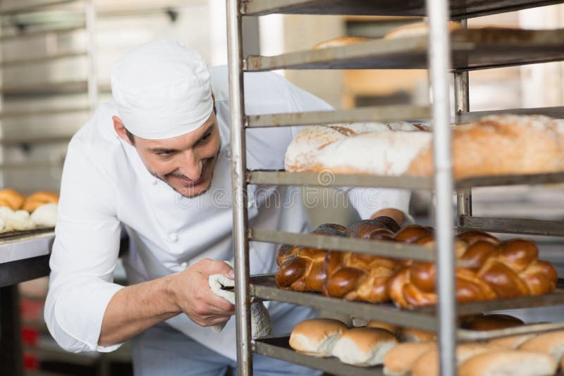 Smiling Baker Pushing Tray of Bread Stock Photo - Image of food, adult ...