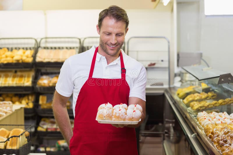 Male Bakery Worker Wearing Red Apron Standing at Bakery Counter Holding ...