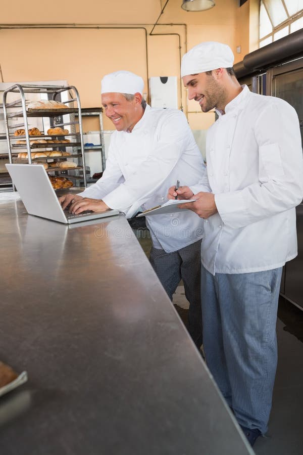 Smiling Bakers Working Together on Laptop Stock Photo - Image of bread ...