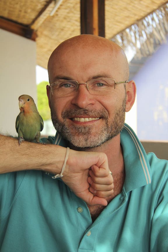 Smiling Bald Man with a Beard with a Parrot Stock Photo - Image of blue ...