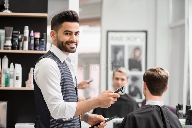 Smiling Barber Sprinkling Water on Client`s Haircut Using Sprayer ... Smiling Barber Sprinkling Water on Client`s Haircut Using Sprayer ...