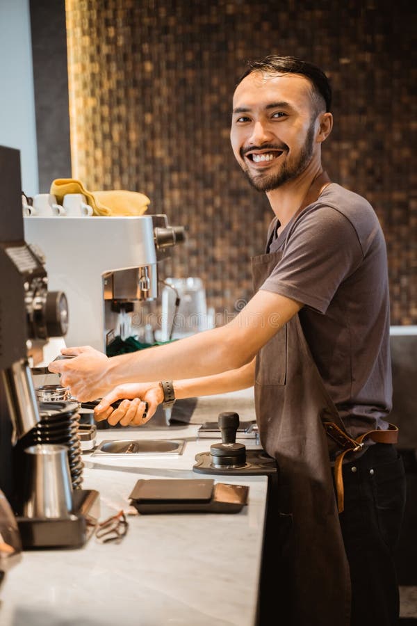 Smiling Barista Using Coffee Grinding Machine at Barista Table Stock ...