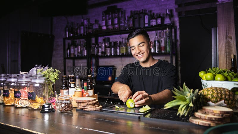 Smiling Bartender Behind a Club Bar Cutting Lime into Pieces Stock ...