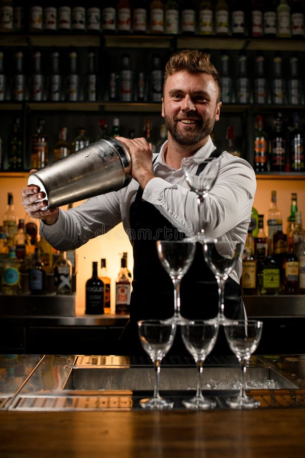 Smiling Bartender Holds Large Shaker in His Hands and Pyramid of Empty ...