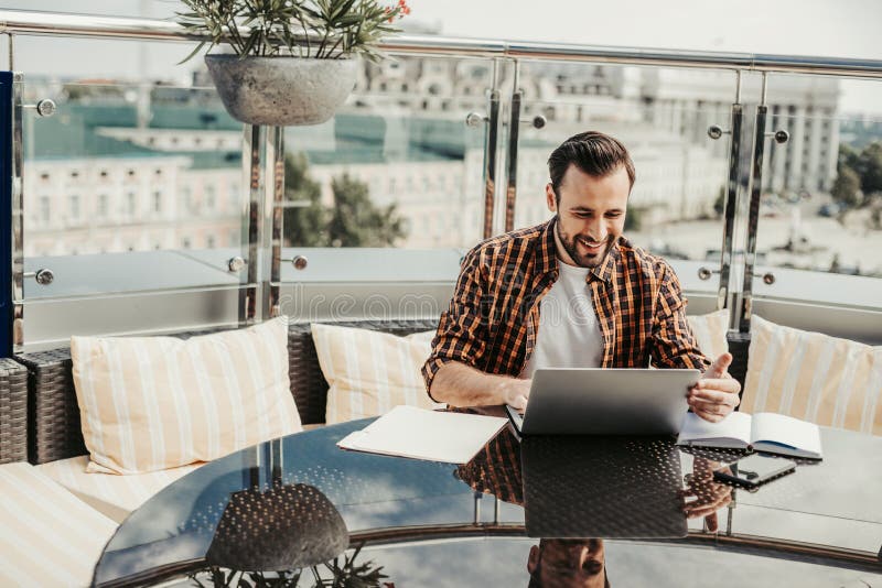 Smiling Bearded Man at Outdoor Cafe Looking at Laptop Stock Photo ...