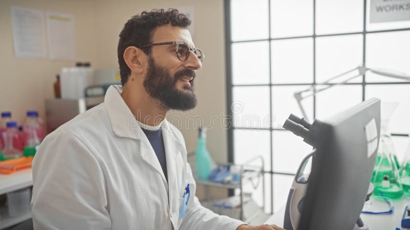 Smiling Bearded Scientist in White Coat Working at a Computer in a ...