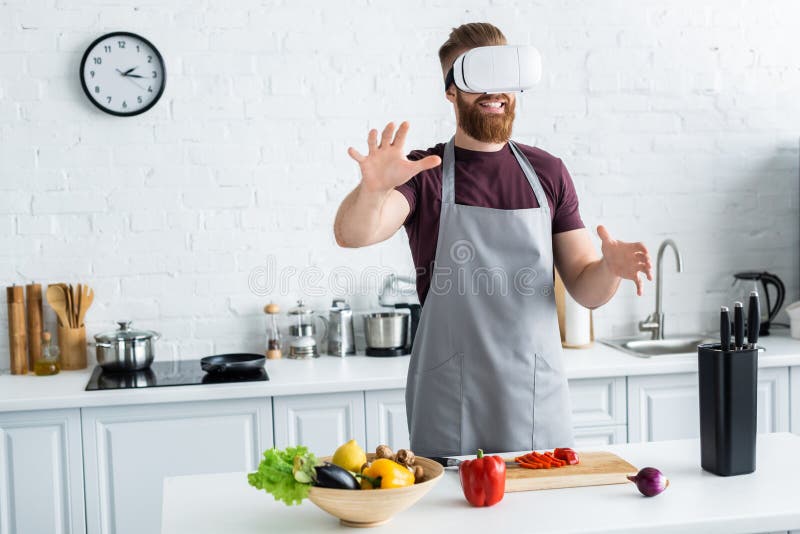 Smiling Bearded Young Man in Apron Using Virtual Reality Headset while ...