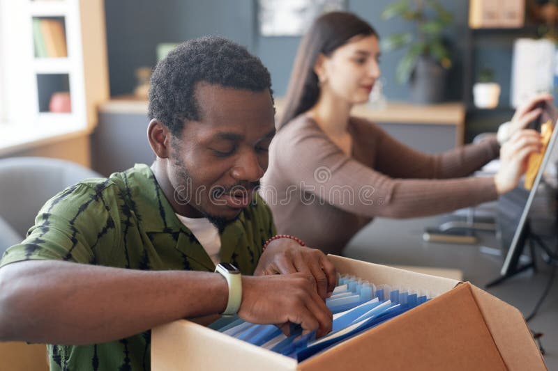 Smiling Black Man Looking through Documents in Folder Box at Office ...