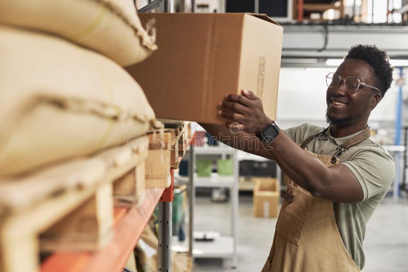 Smiling Black Man Picking Up Boxes from Shelves in Warehouse Stock ...