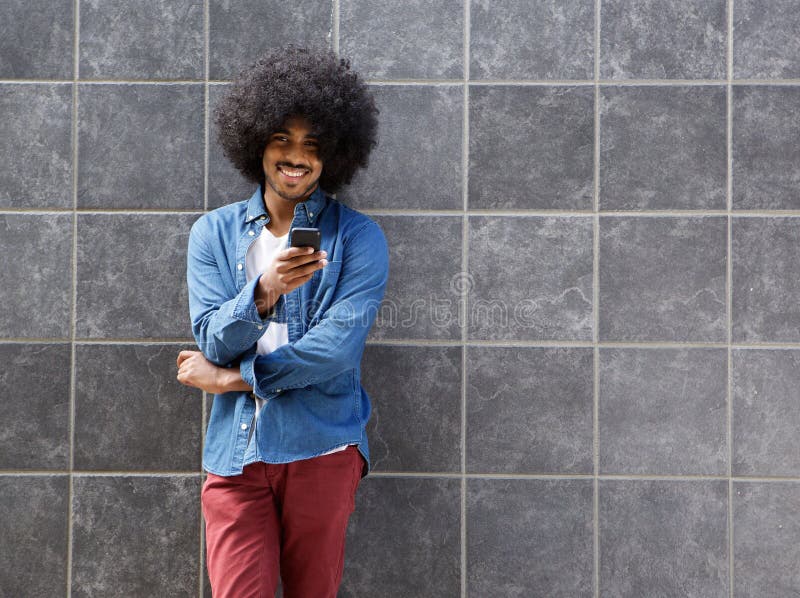 Smiling Black Man Standing with Mobile Phone Outside Stock Photo ...