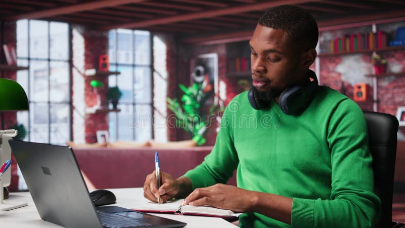 Smiling Black Man Taking Notes while Watching a Tutorial Presentation ...