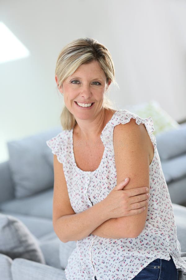 Portrait Of A Beautiful Older Woman Smiling And Standing With Arms