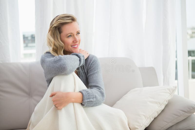 Smiling Blonde Sitting on Her Couch Thinking Stock Image - Image of ...
