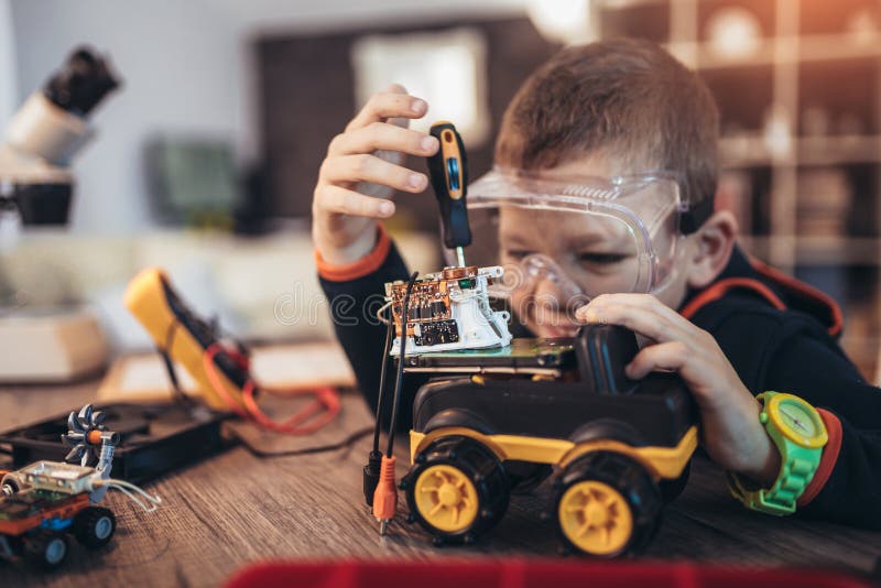 Smiling Boy Constructs Technical Toy. Technical Toy on Table Full of ...