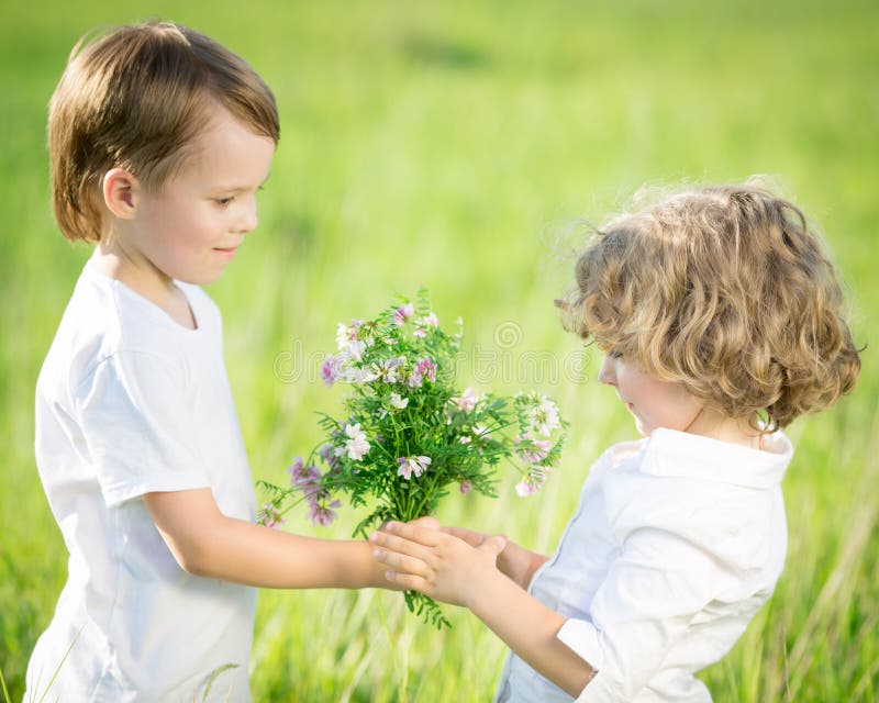 Young Boy Giving Young Girl Flowers and Smiling Stock Photo - Image of ...