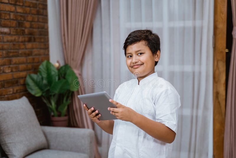 A Smiling Boy Holding a Tablet is Standing Stock Photo - Image of ...