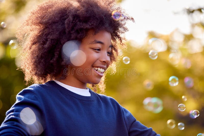 Smiling Boy Outdoors Having Fun Playing with Bubbles in Garden Stock ...
