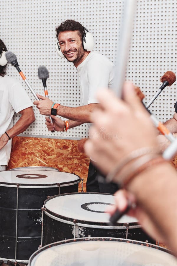 Smiling Boy Playing the Drum with Some Maces among a Group of Musicians ...