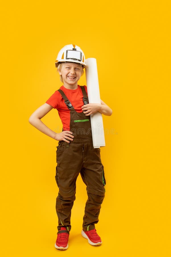 Smiling Boy in Protective Helmet, Overalls and with Roll of Paper in ...