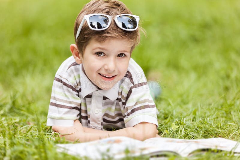 Smiling Boy Reading Book Outdoor Stock Photo - Image of caucasian ...