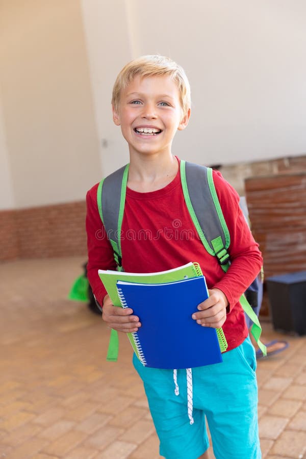 Smiling Boy in School Holding Notebooks and Wearing Backpack, Ready for ...