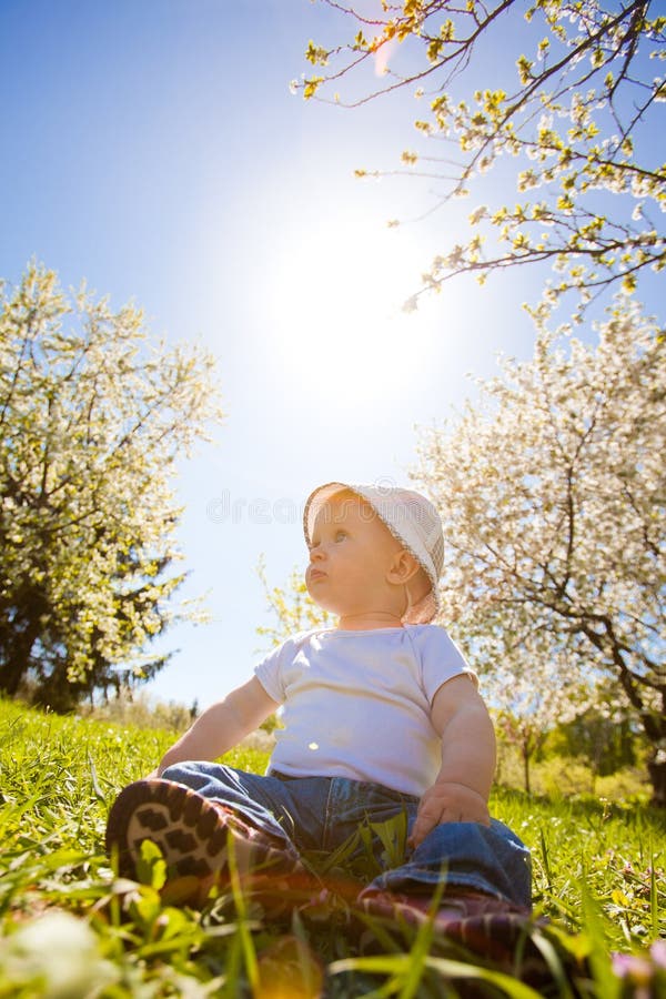 Smiling Boy Sits on a Grass Under Sun Beams Stock Photo - Image of ...