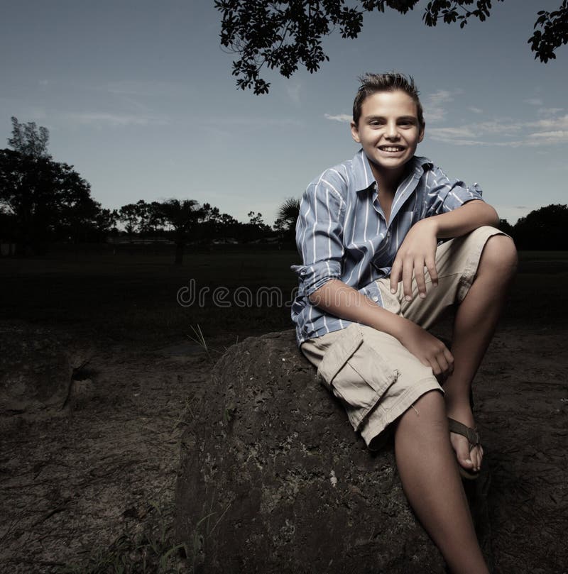 Smiling Boy Sitting on a Rock Stock Image - Image of sitting, happy ...