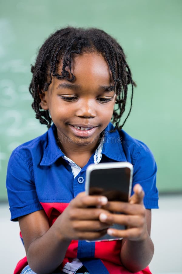 Smiling Boy Using Mobile Phone in Classroom Stock Photo - Image of ...