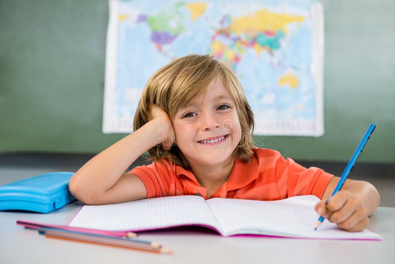 Front View of Boy Writing on Book in Classroom Stock Photo - Image of ...