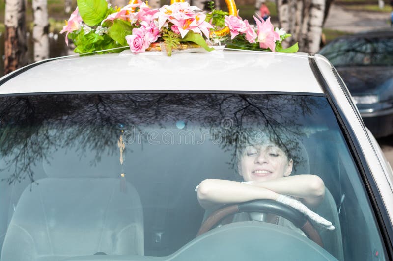 Smiling Bride Looking through the Windshield while Sitting on Driver ...