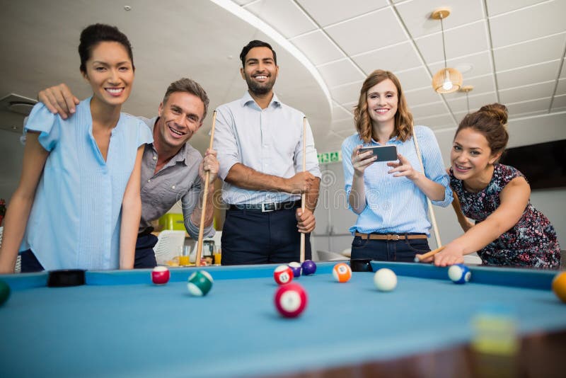 Smiling Business Colleagues Playing Pool in Office Space Stock Image ...