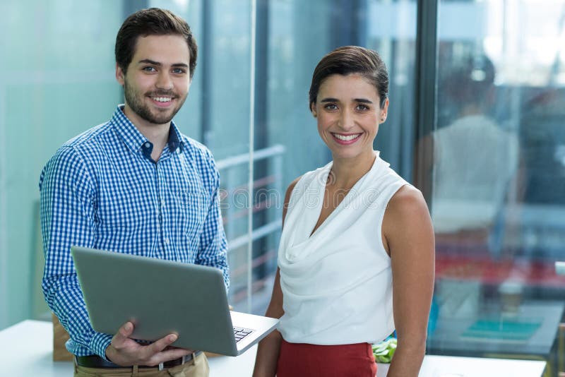Smiling Business Executives Standing in Office with Laptop Stock Image ...