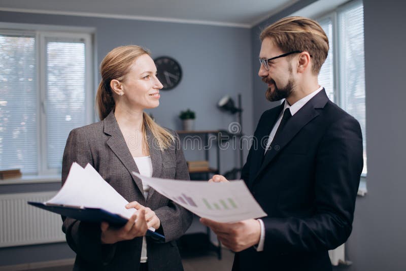 Smiling Business Partners Standing at Office with Documents Stock Photo ...