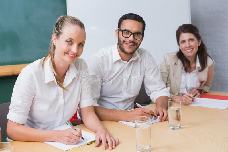 Smiling Business People Taking Notes during Meeting Stock Photo - Image ...