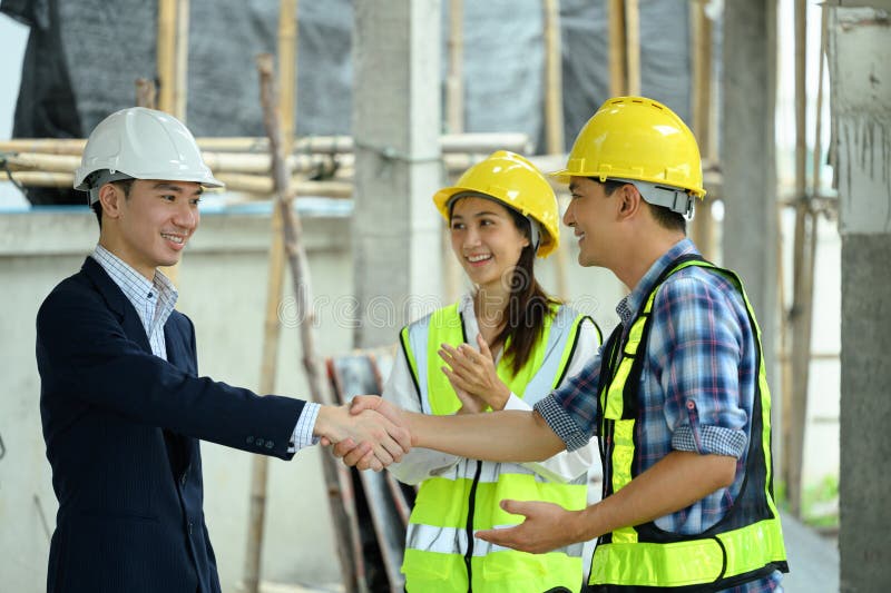 Smiling Businessman in Black Suit and Engineer Shaking Hands with ...