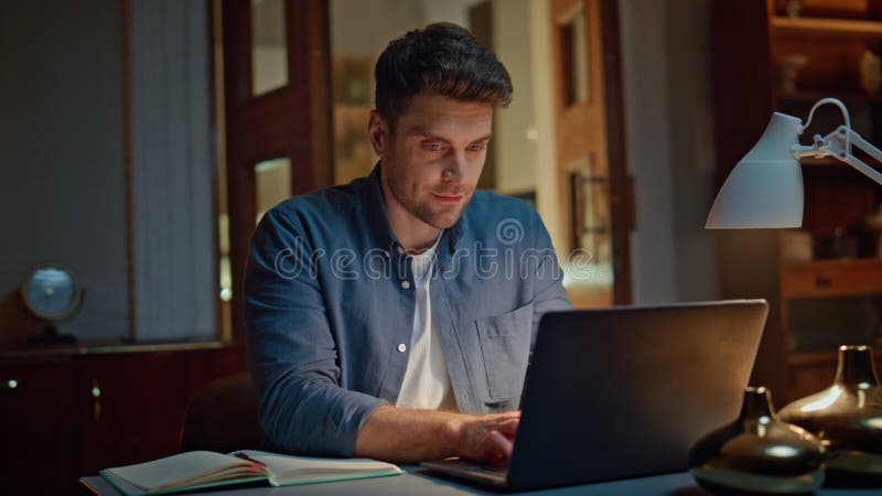 Smiling Businessman Browsing Computer Texting Email at Cozy Dark Flat ...