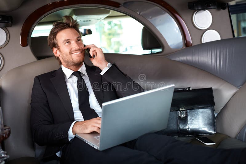 Smiling Businessman In Luxury Car Working Stock Image - Image: 22953739