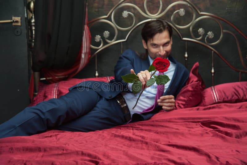 Smiling Businessman Lying on Bed with Flower Stock Photo - Image of ...