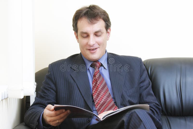 Smiling Businessman Reading Magazine Stock Photo - Image of office ...