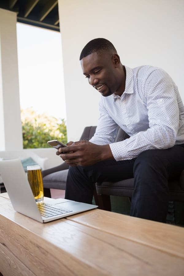 Smiling Businessman Using Phone while Sitting on Couch Stock Photo ...