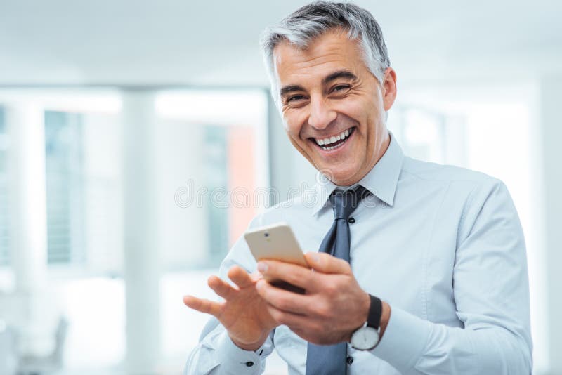 Smiling Businessman Using a Smart Phone Stock Photo - Image of mature ...