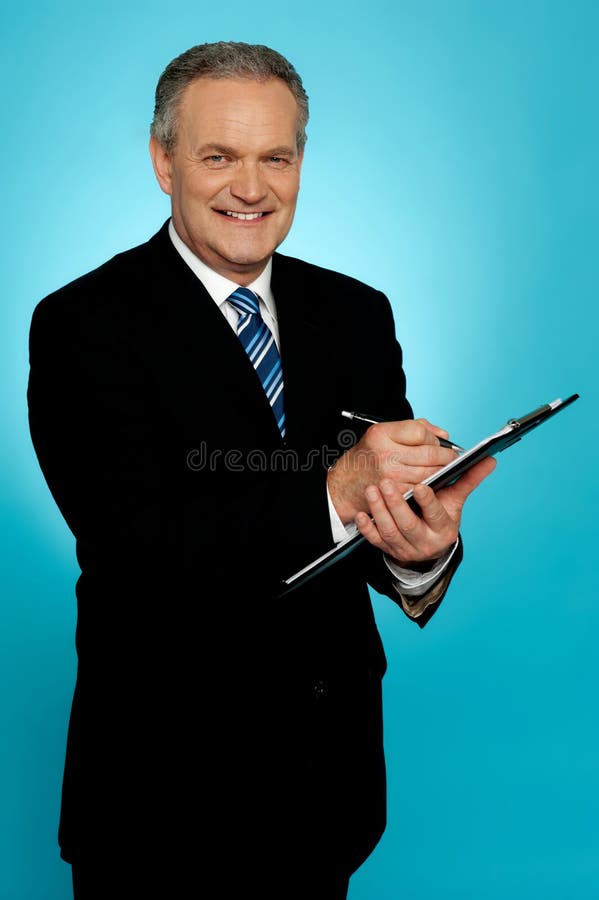 Smiling Businessman Writing on Clipboard Stock Photo - Image of ...