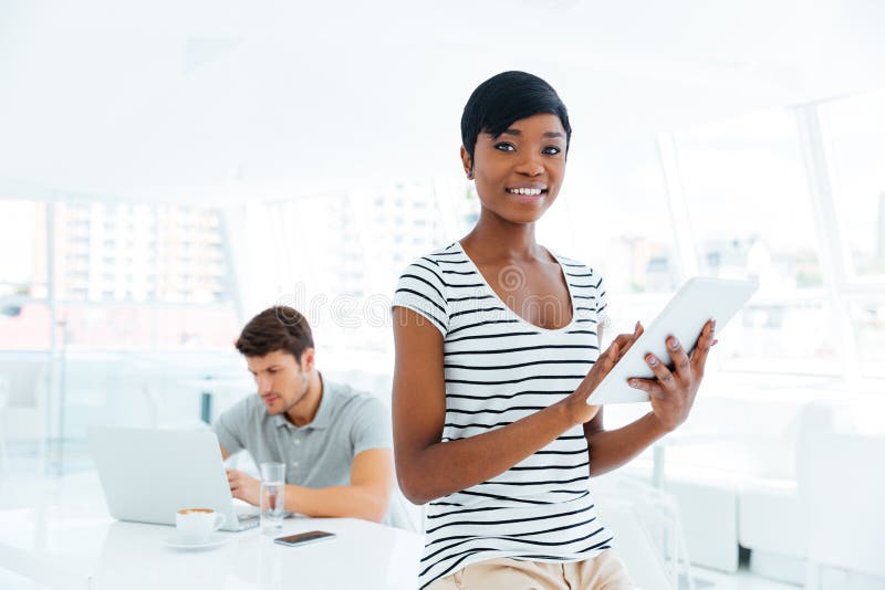 Smiling Businesspeople with Tablet Sitting at the Table and Working ...
