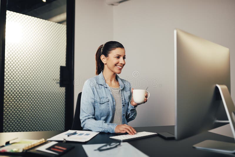 Smiling Businesswoman Drinking Tea while Working at Her Desk Stock ...