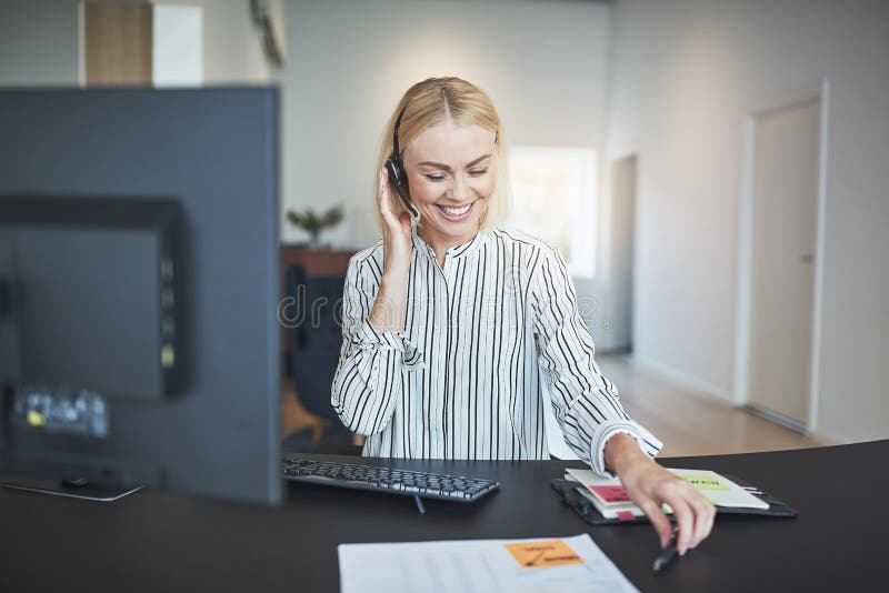 Smiling Businesswoman Talking on a Headset at Her Office Desk Stock ...
