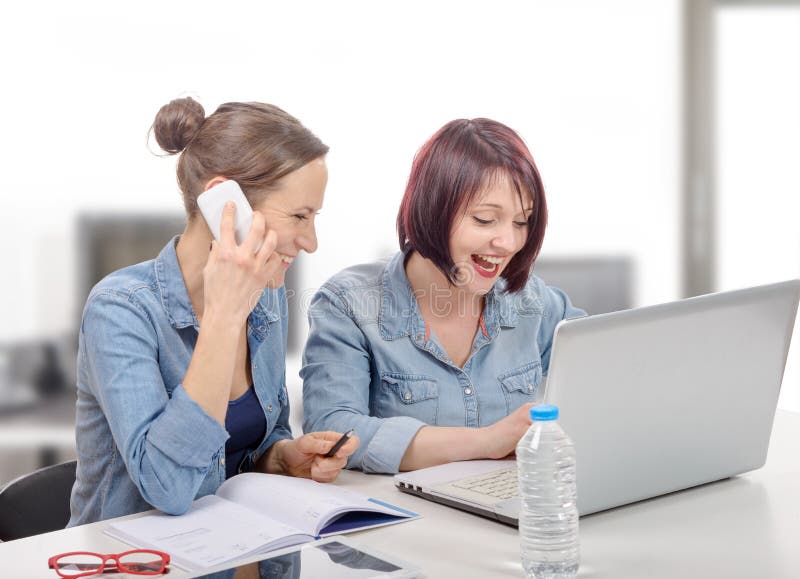 Smiling Businesswomen Using Cell Phone in Office Stock Image - Image of ...